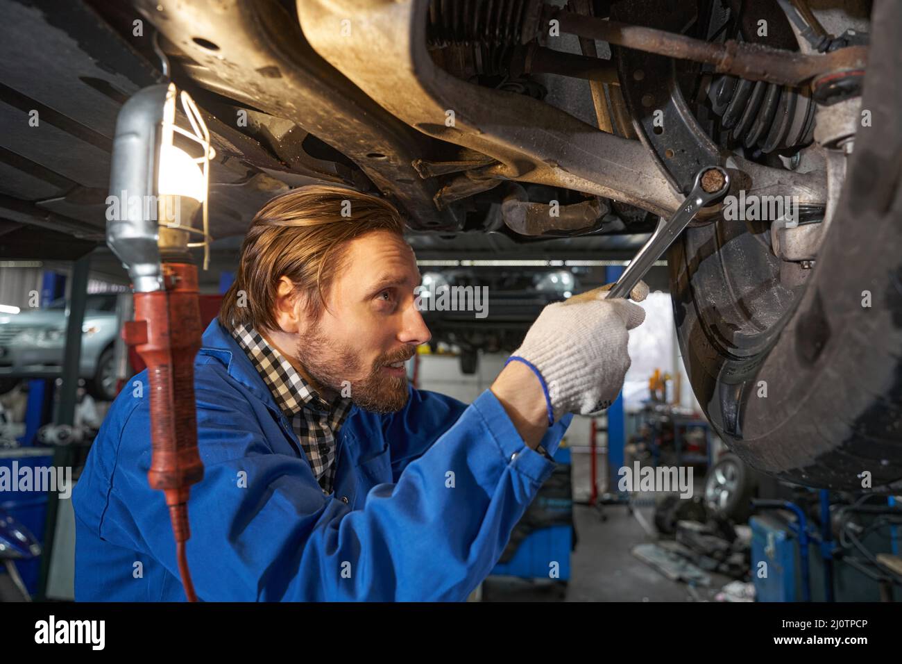 Portrait of man performing machine diagnostics at service station Stock ...