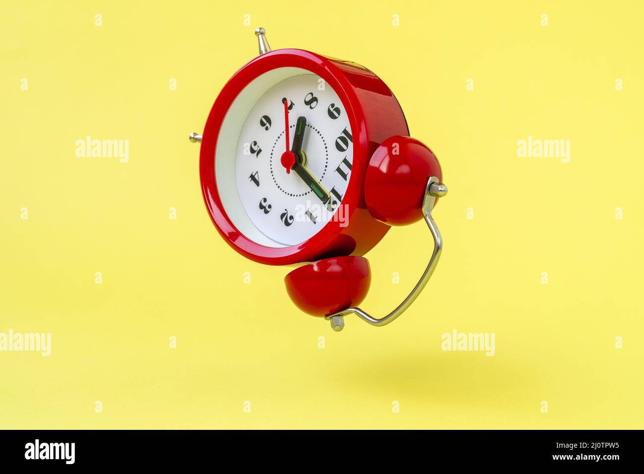 Red alarm clock floating on the air Stock Photo - Alamy