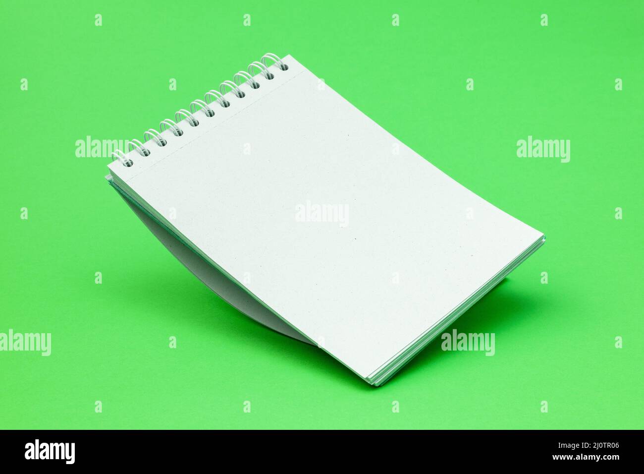 Blank spiral notebook falling on the green background Stock Photo - Alamy