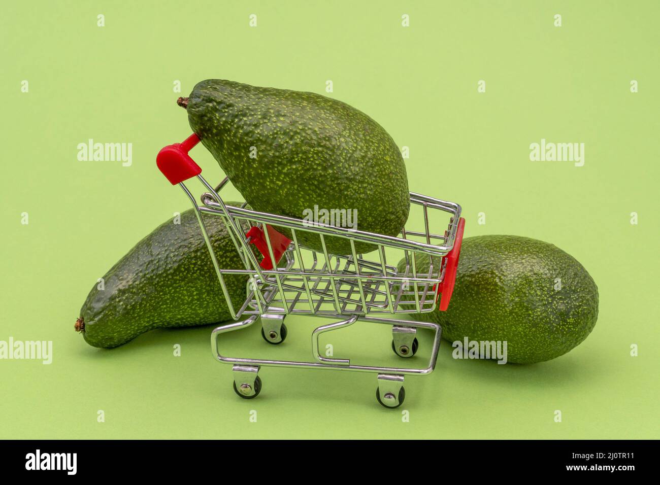 Avocado fruits and shopping grocery cart Stock Photo - Alamy