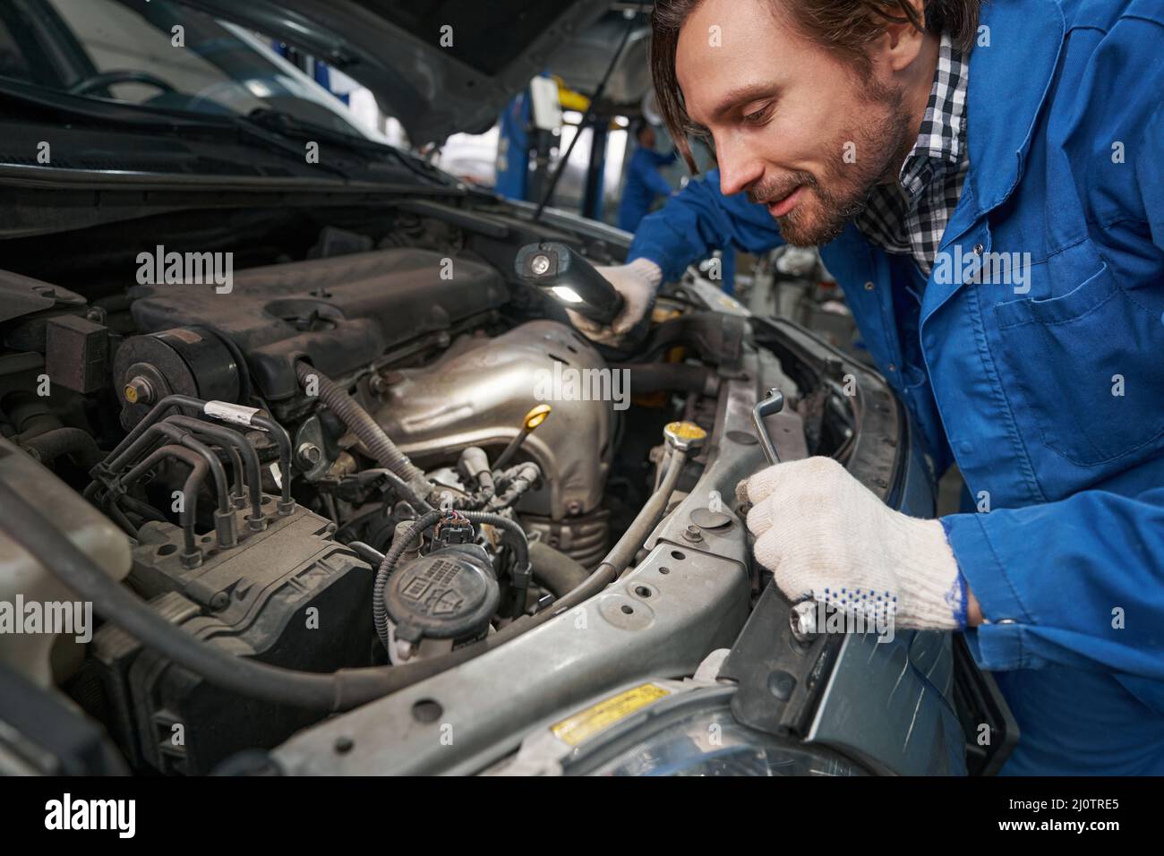 Man with tool working in service center Stock Photo - Alamy
