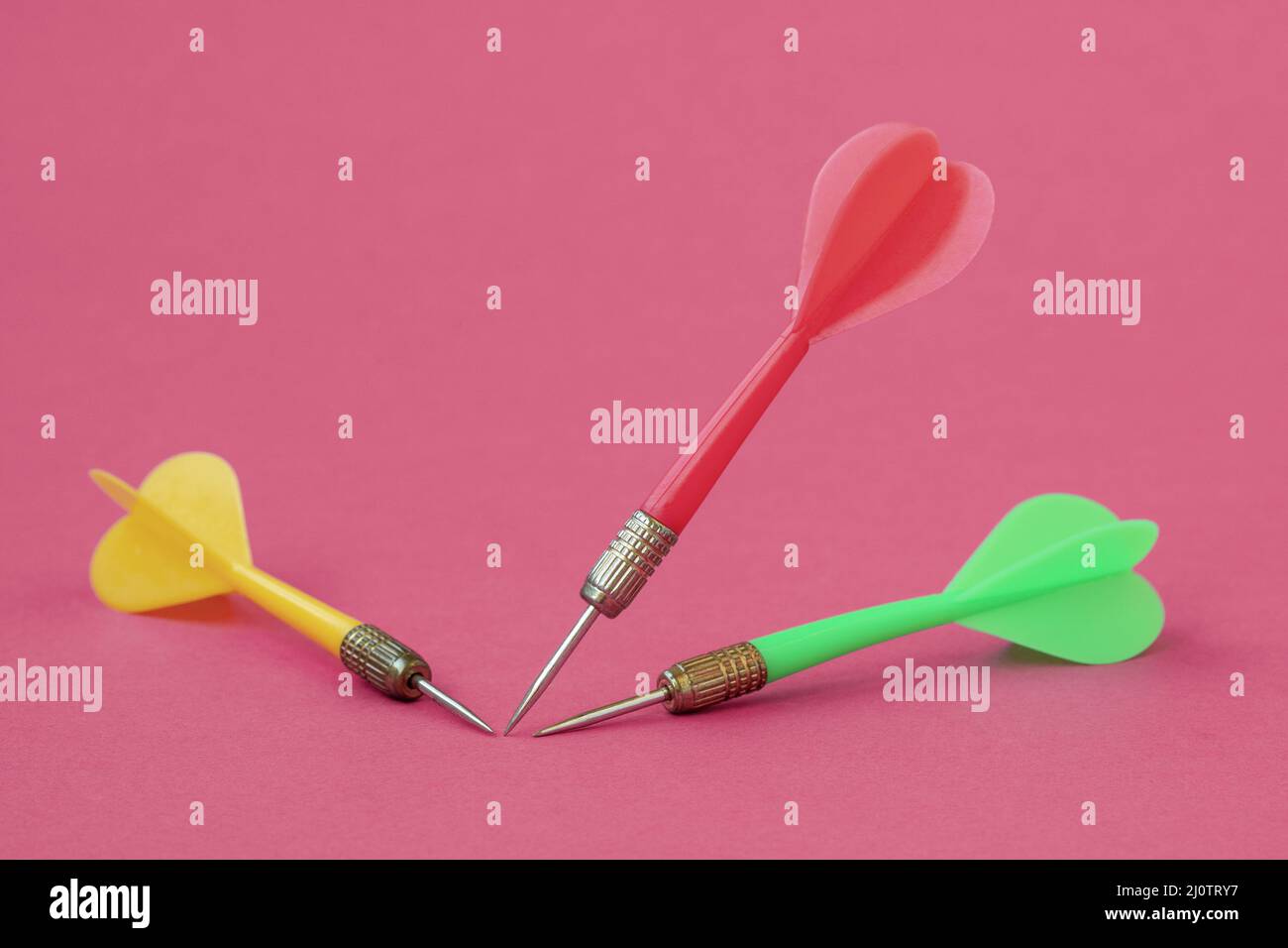 Three dart arrows on the pink background Stock Photo - Alamy