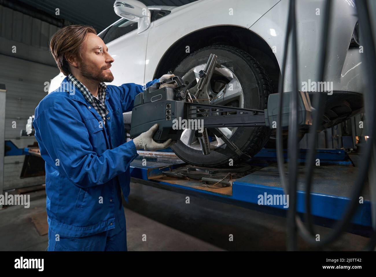 Professional worker performing car maintenance at service station Stock ...
