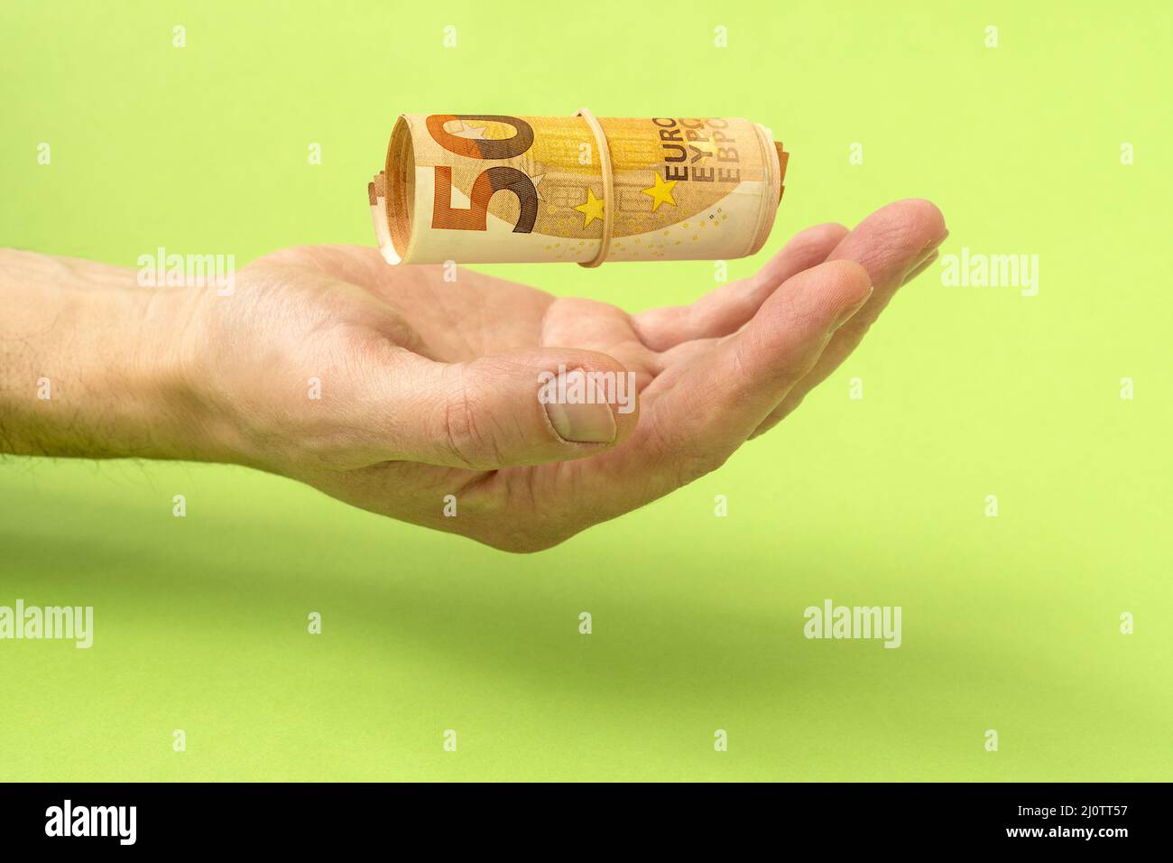 Hand catching a falling money roll Stock Photo - Alamy
