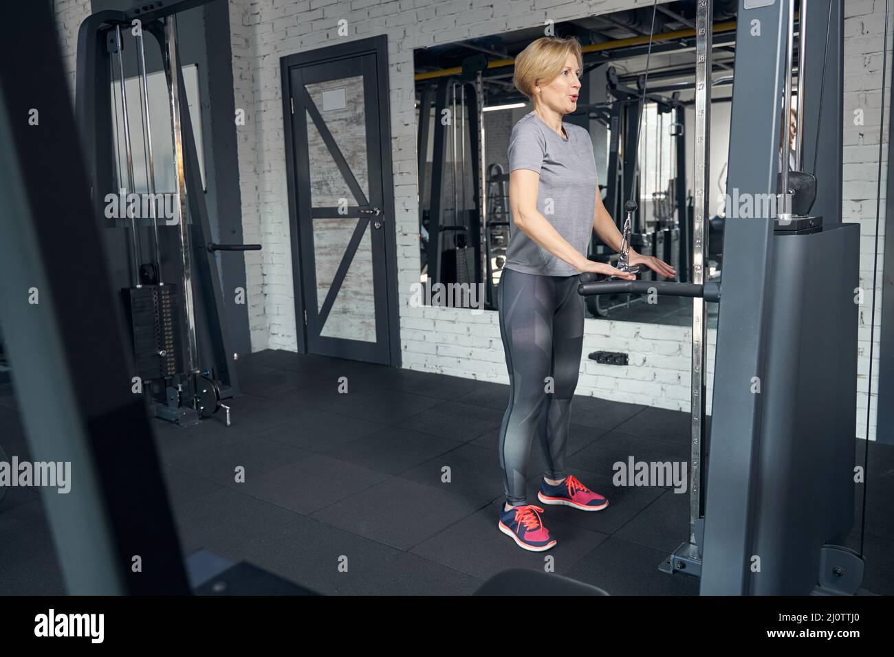 Sporty woman using gym trainer during strength workout Stock Photo - Alamy
