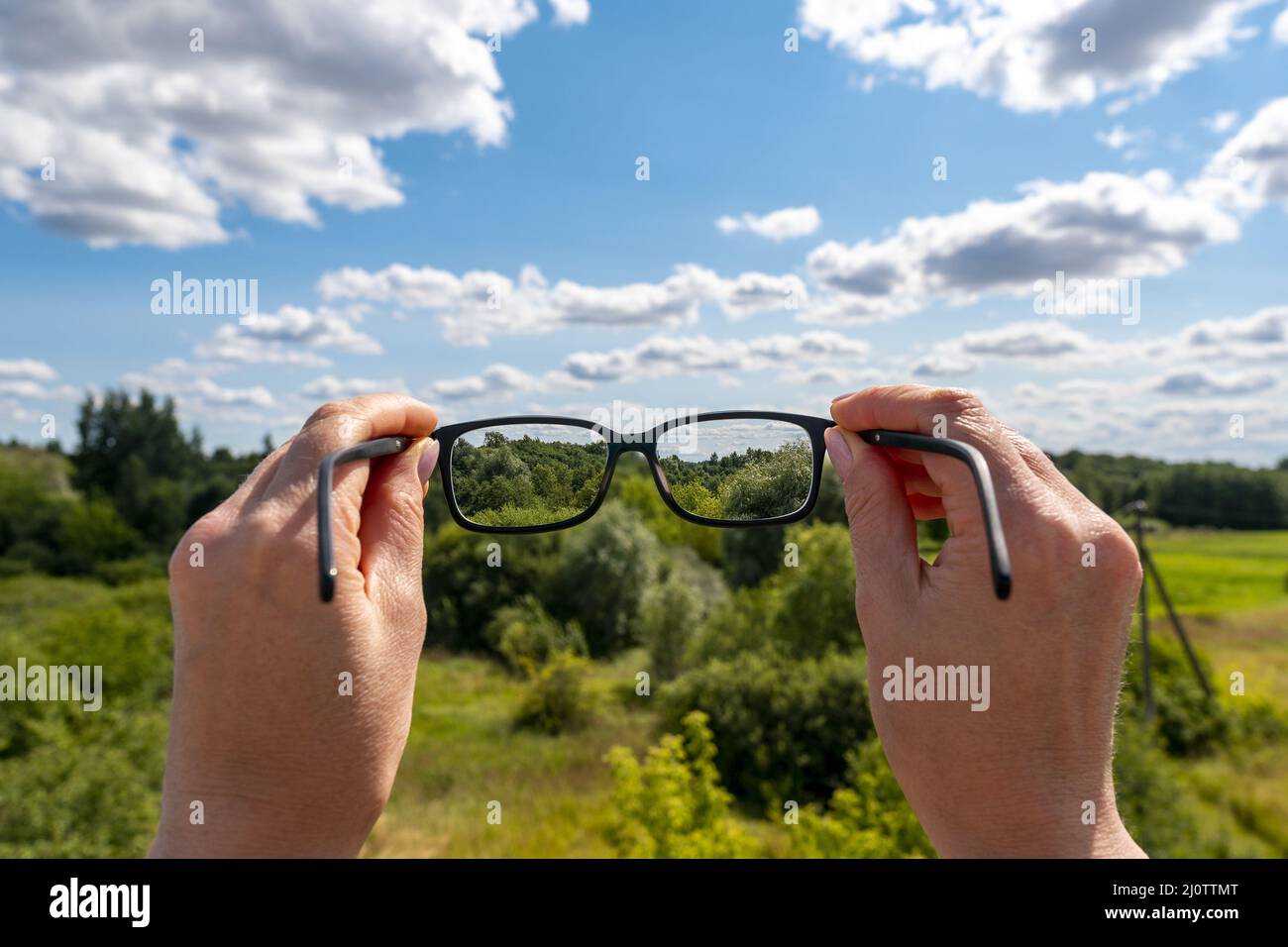 Hands holding a glasses that correct the vision Stock Photo - Alamy