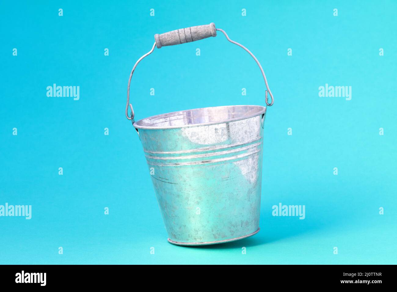Metal bucket on the blue background Stock Photo - Alamy