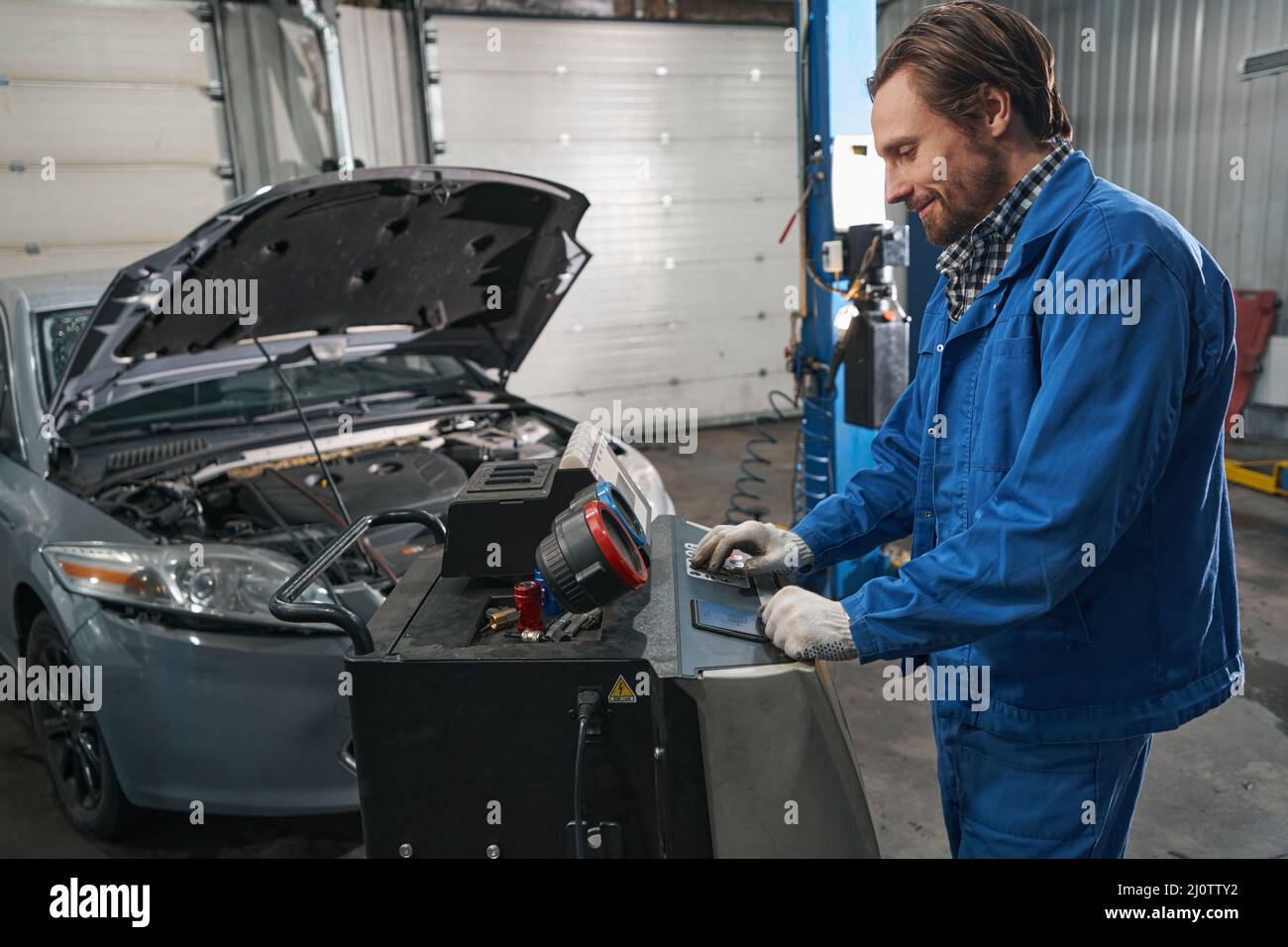 Mechanic working at service center and checking compression ratio Stock ...