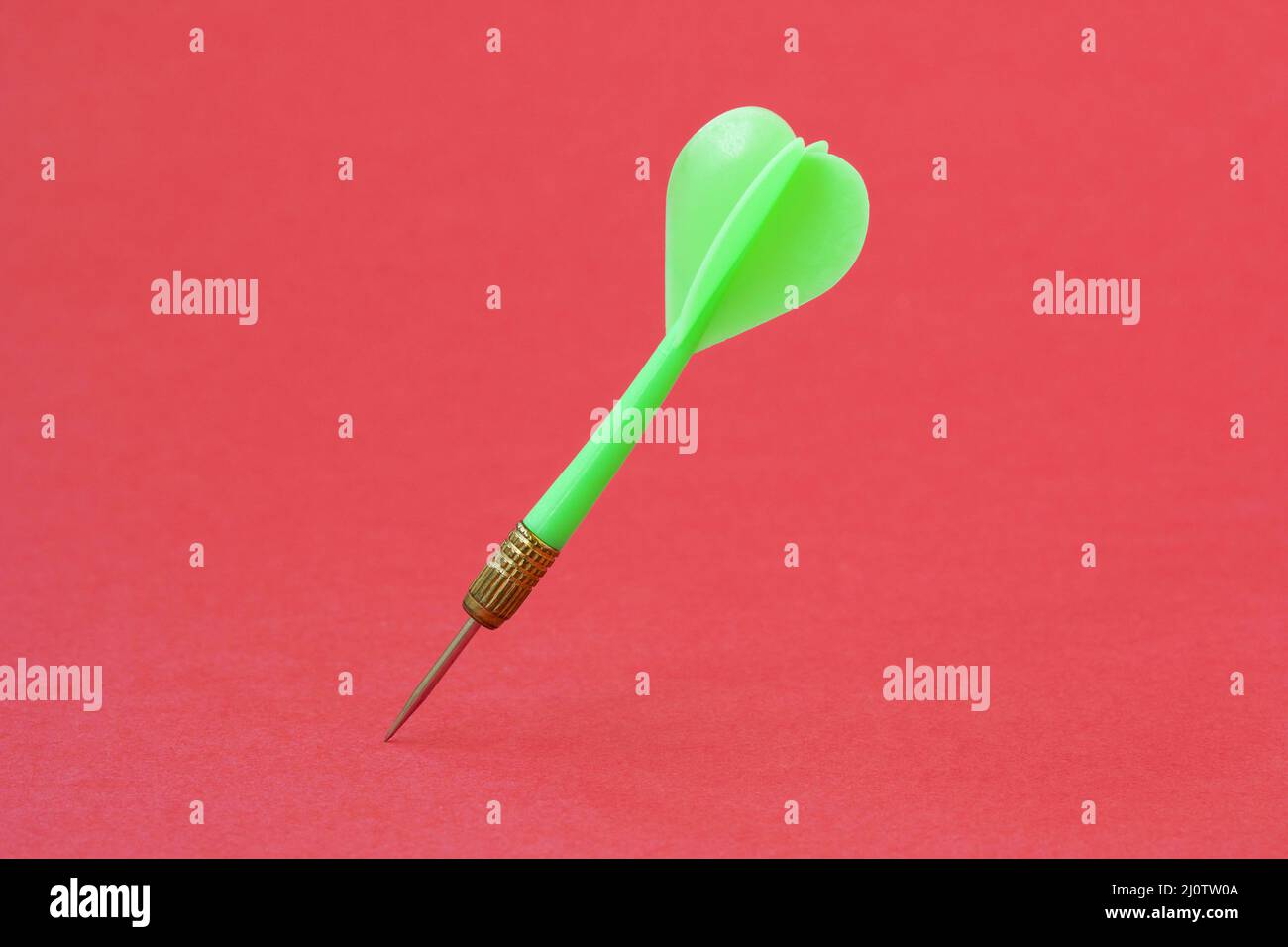 Green dart arrow on the red background Stock Photo - Alamy