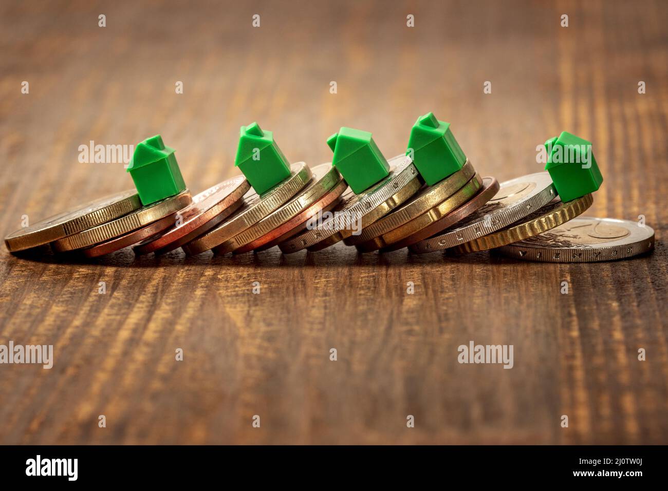 Pile of coins with many house plastic models Stock Photo - Alamy