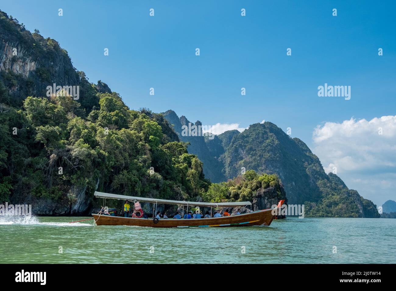 Tour boat among the scenic limestone islands in Phang Nga Bay. This is ...