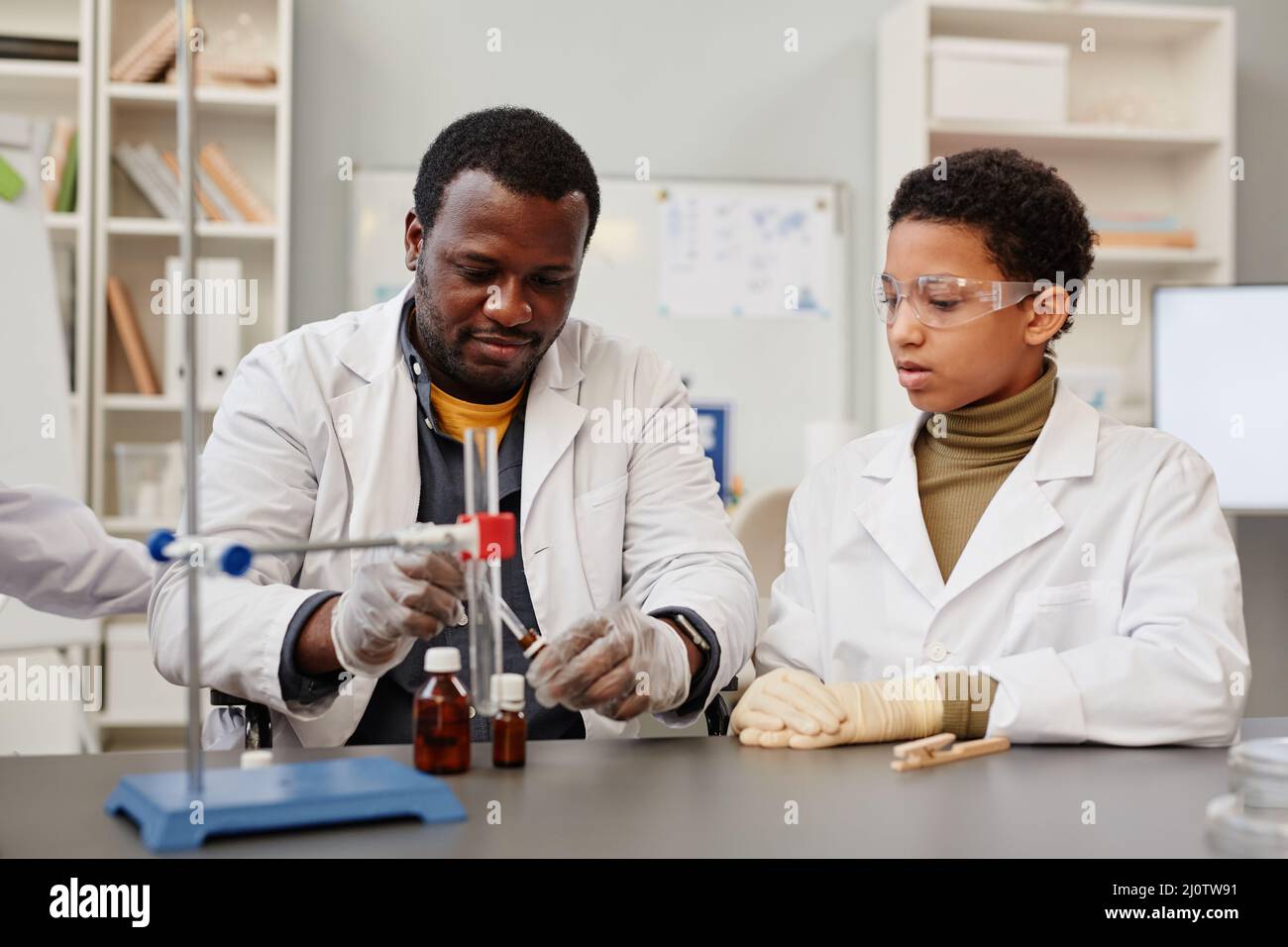 Portrait of African American teacher demonstrating science experiments ...