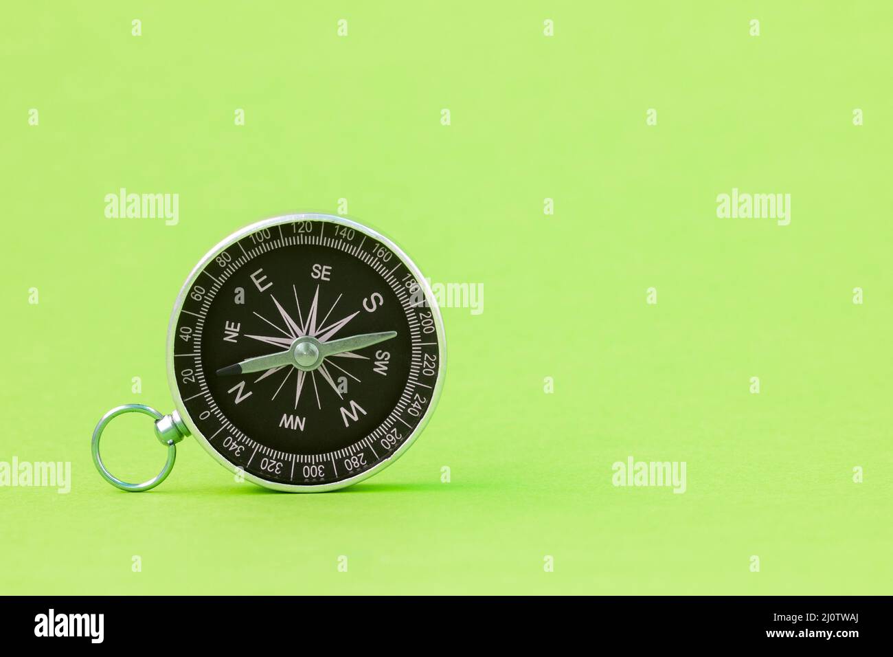 Black compass on the green background Stock Photo - Alamy