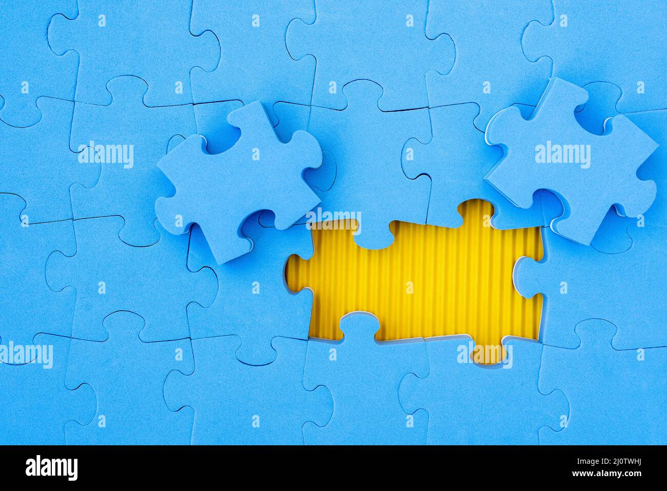 Two puzzle pieces revealing yellow space Stock Photo - Alamy
