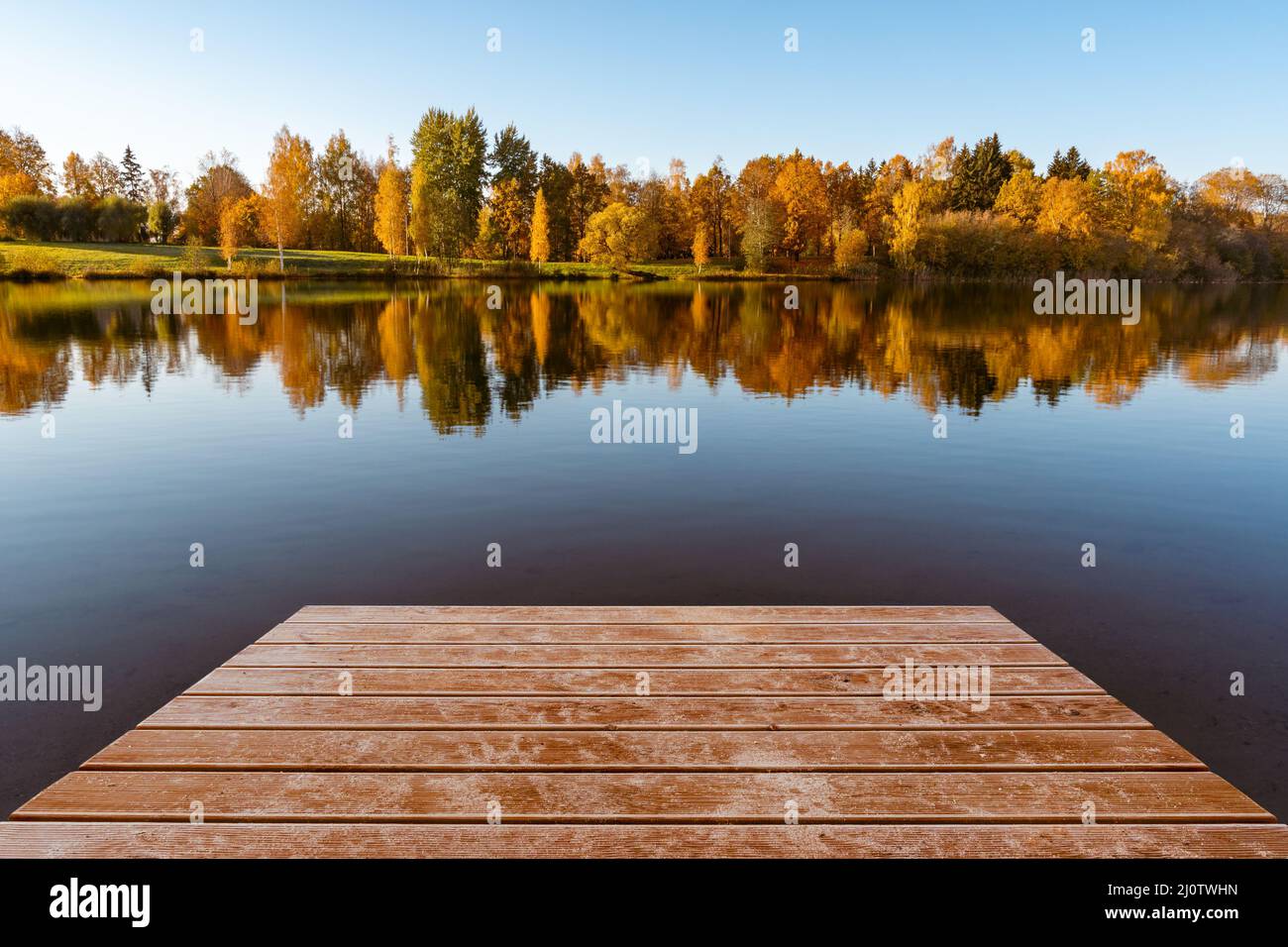 Wooden pier and colorful foliage reflections in lake water Stock Photo ...