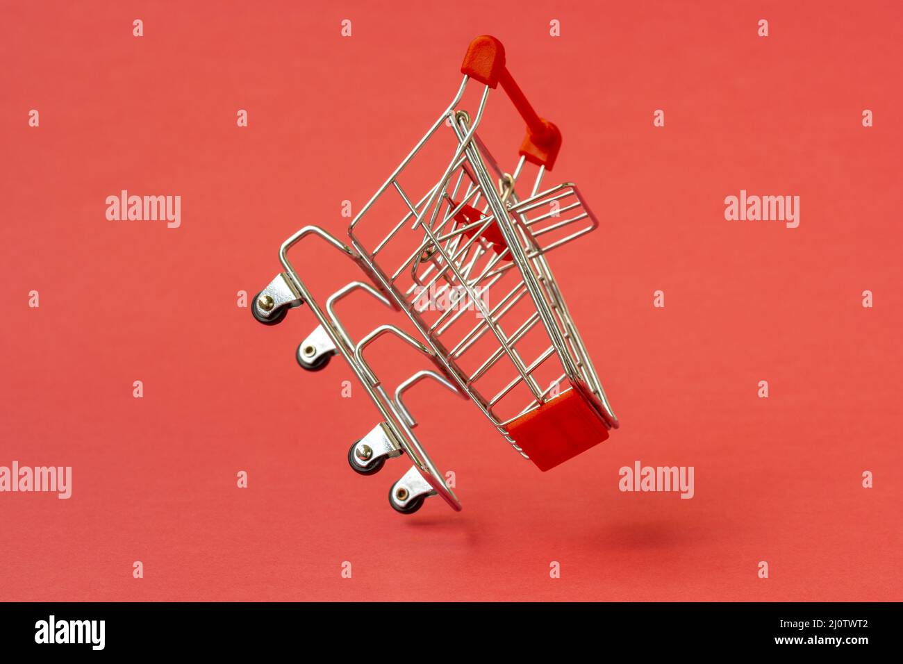 Metal mini shopping trolley on a red background Stock Photo - Alamy