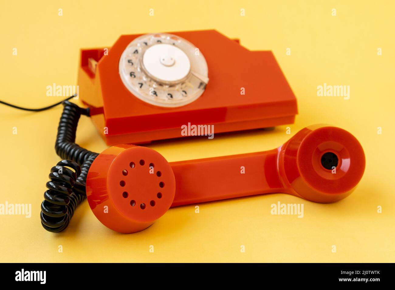 Retro orange telephone on yellow background Stock Photo - Alamy
