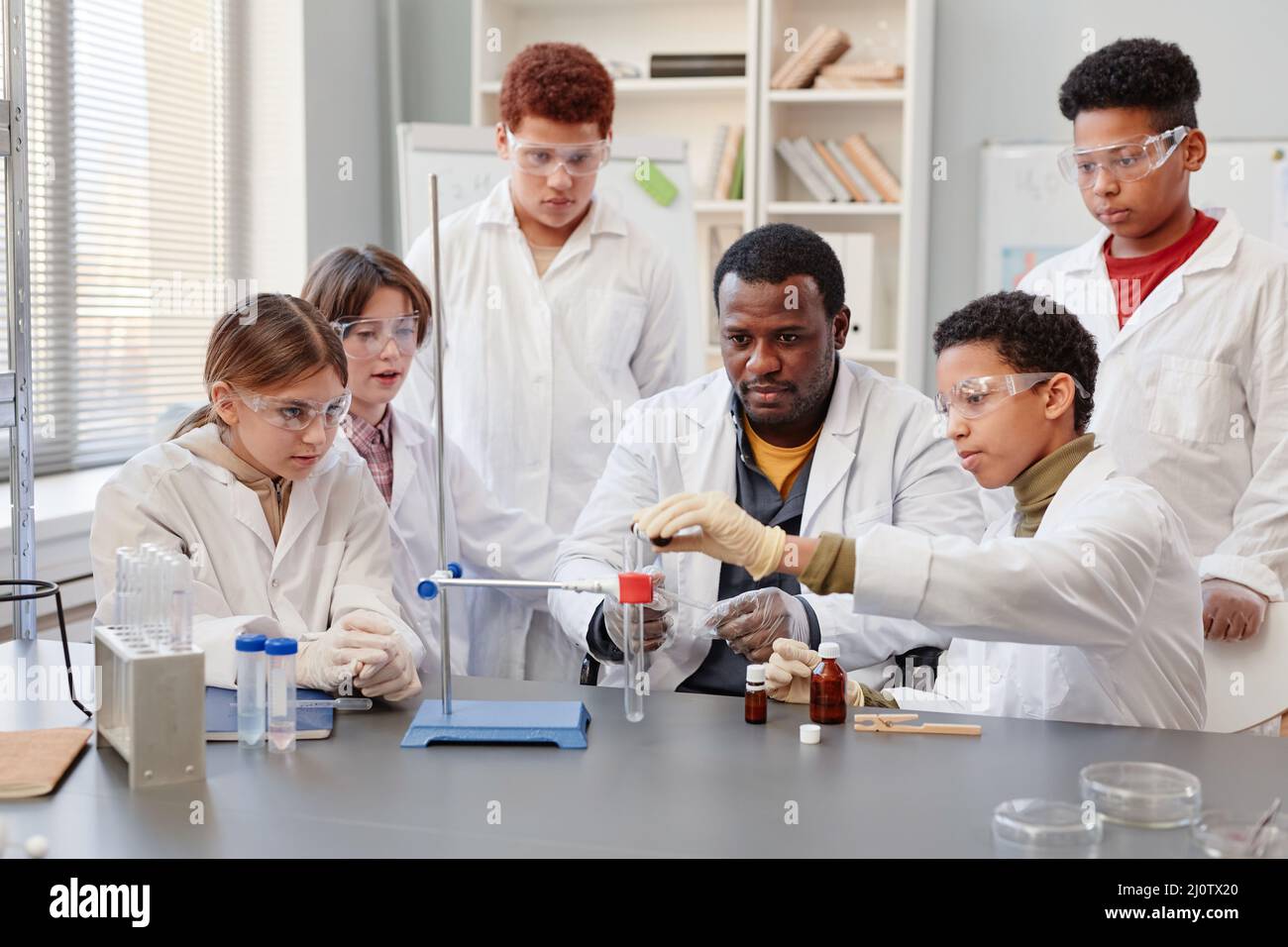 Portrait of African American teacher demonstrating science experiments ...