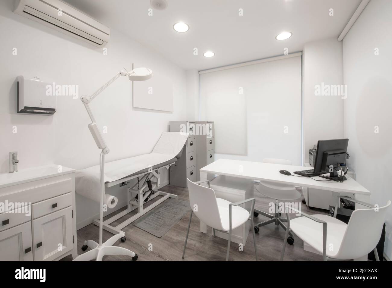 Paper-topped table in a beauty clinic with gray file cabinets, a desk ...