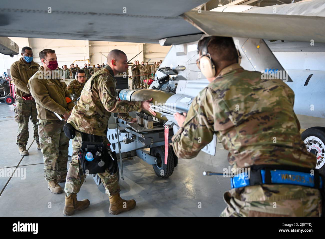 Airmen from the 311th Aircraft Maintenance Unit load an inert bomb ...