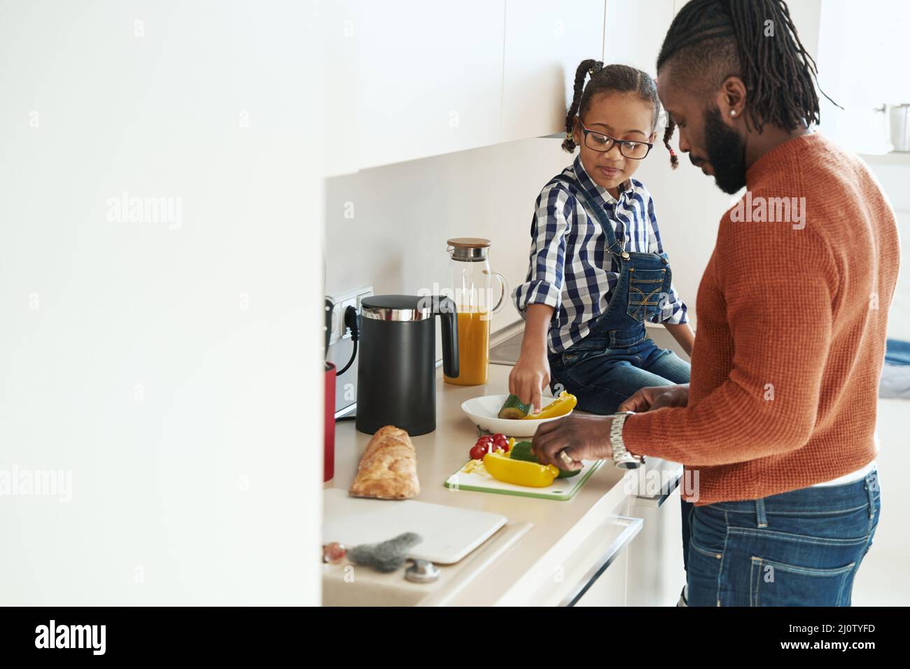 African American male cooking in the kitchen with his young daughter ...