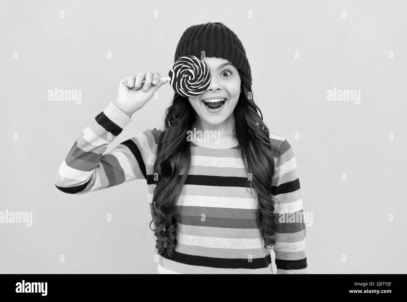 hipster kid with colorful lollypop sugar candy on stick. caramel candy ...