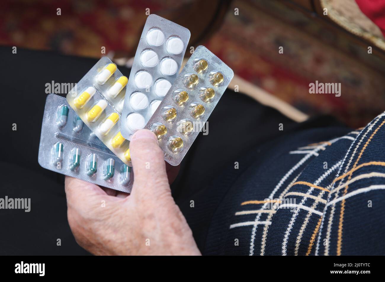 Different pills in the hands of an old woman. The concept of problems ...