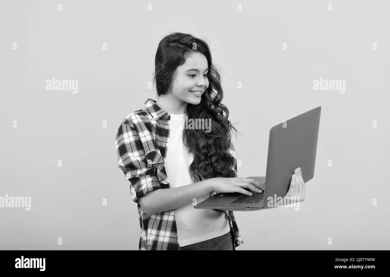 happy smart kid typing on laptop during school online lesson, modern ...