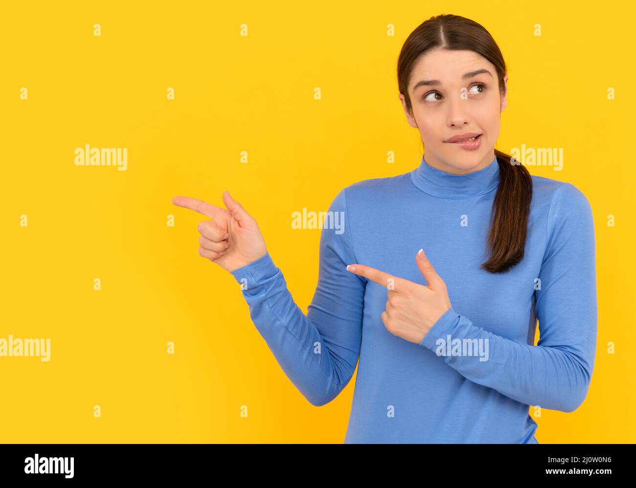 pondering woman portrait pointing fingers on copy space yellow ...