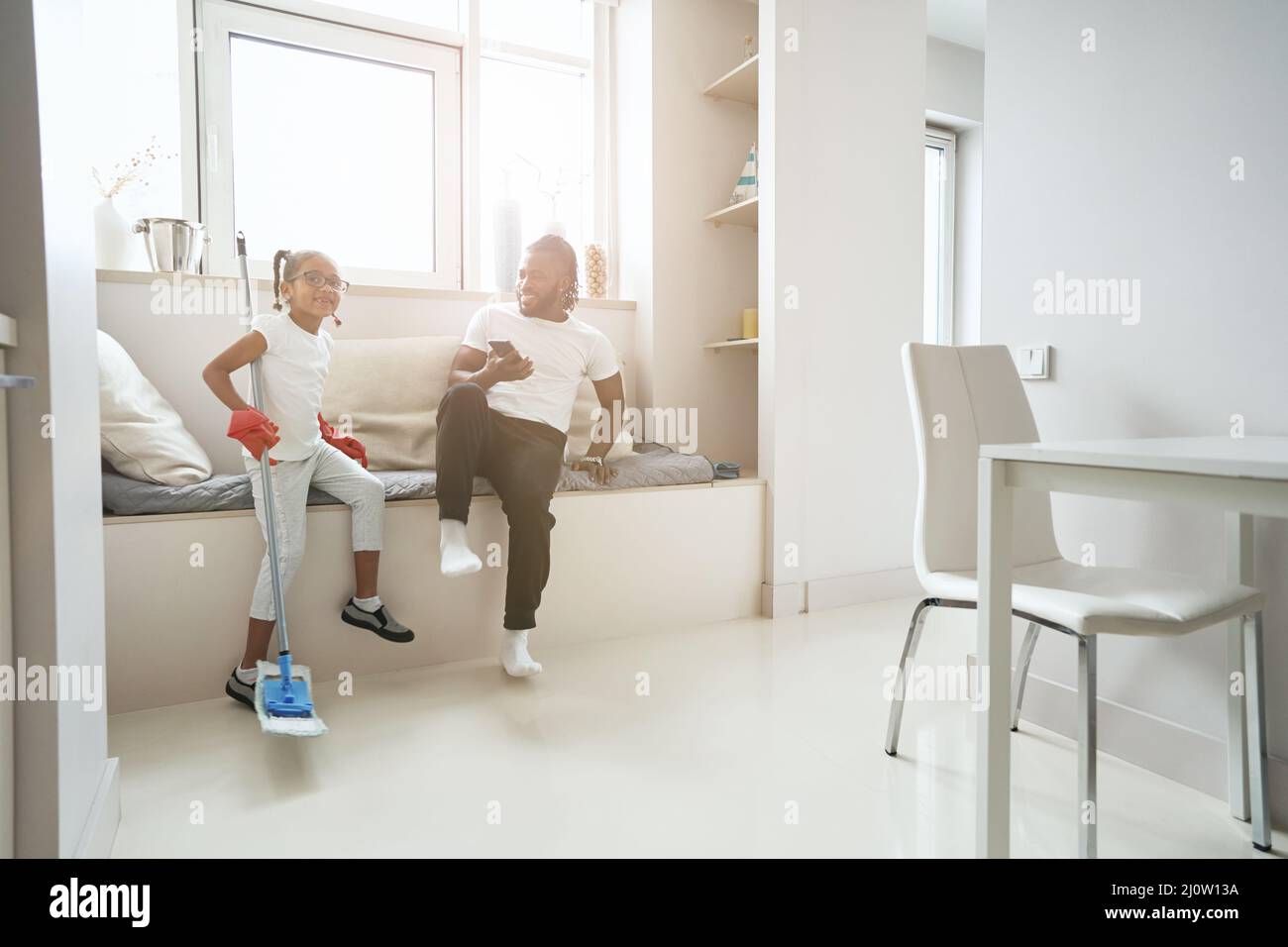 Joyful girl getting ready to clean with her father Stock Photo - Alamy