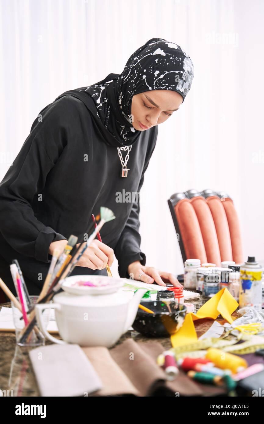 Woman in hijab making designes of traditional clothes Stock Photo - Alamy