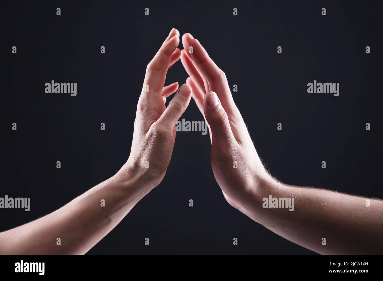 A close-up of two hands male and female gently touch each other. The ...