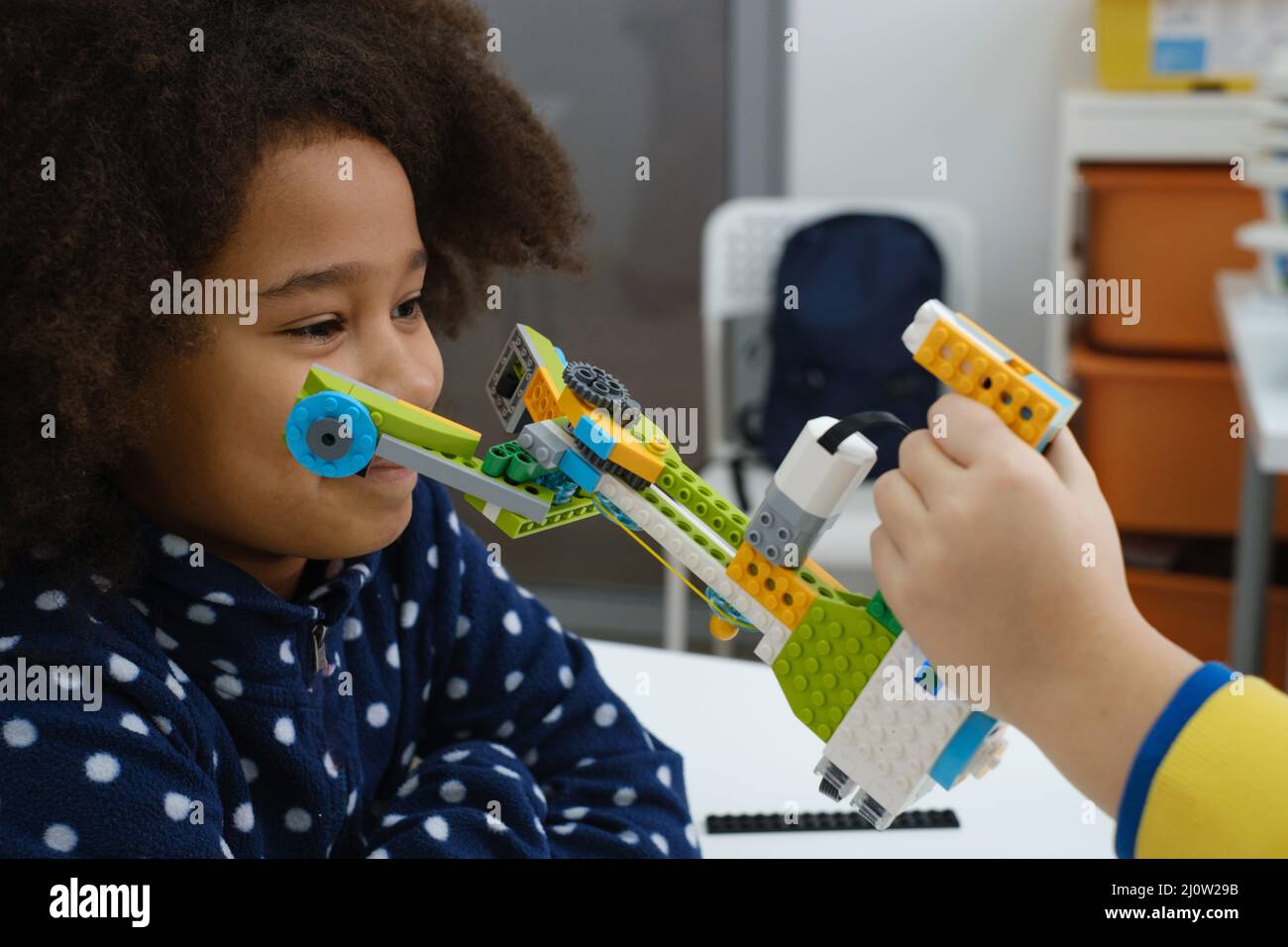 Coding Class, school girl constructing robot arm mechanism. multiethnic ...