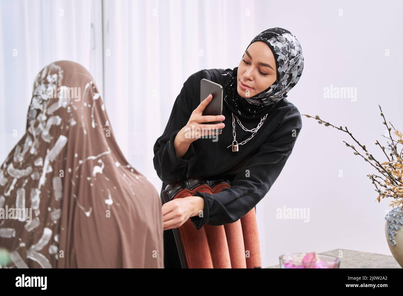 Smiling muslim designer taking photo of her work Stock Photo - Alamy
