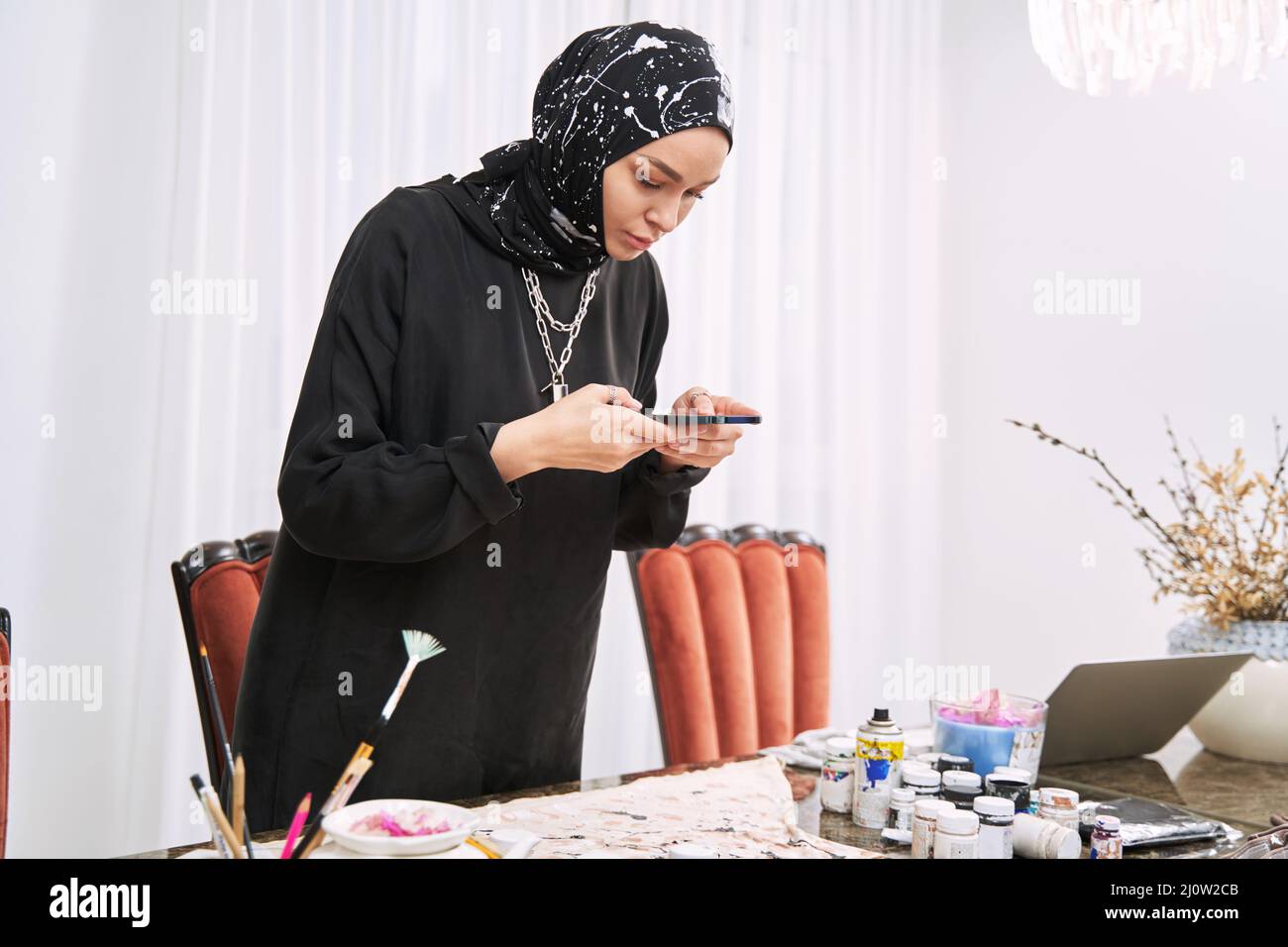 Muslim female designer taking photo of her works Stock Photo - Alamy