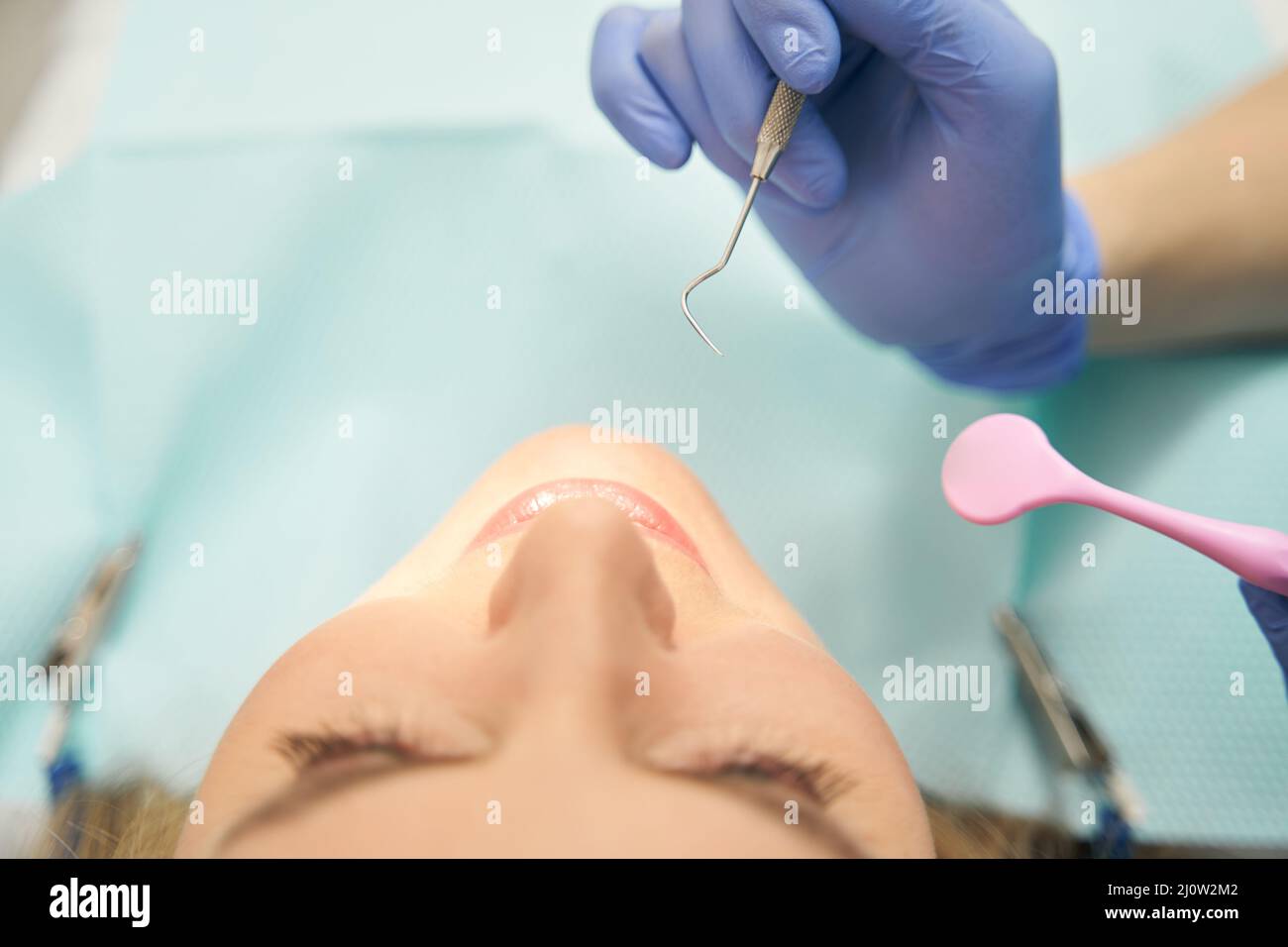 Dentist examining woman teeth with dental tools Stock Photo - Alamy