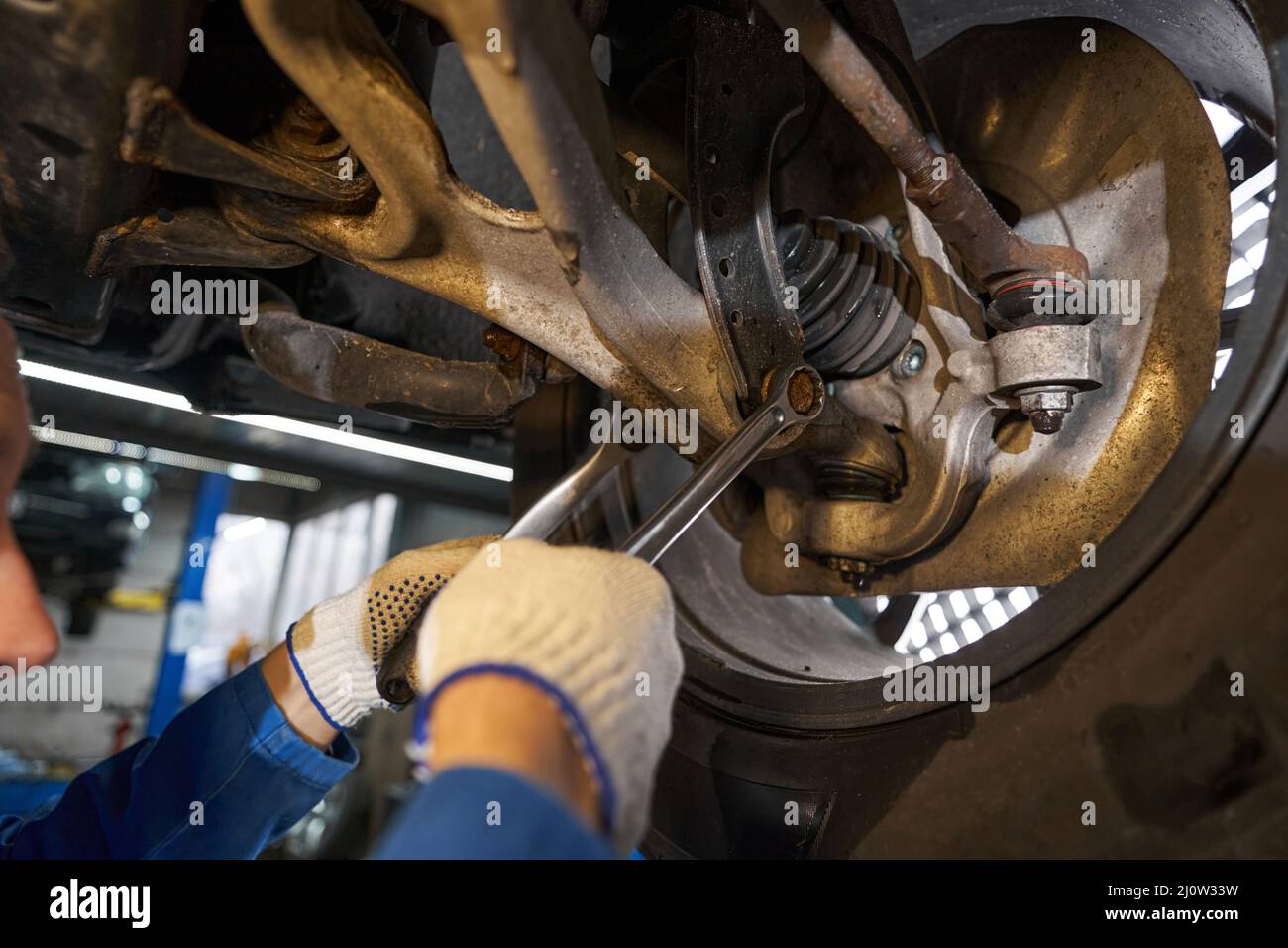Man holding instrument and repairing car at service station Stock Photo ...