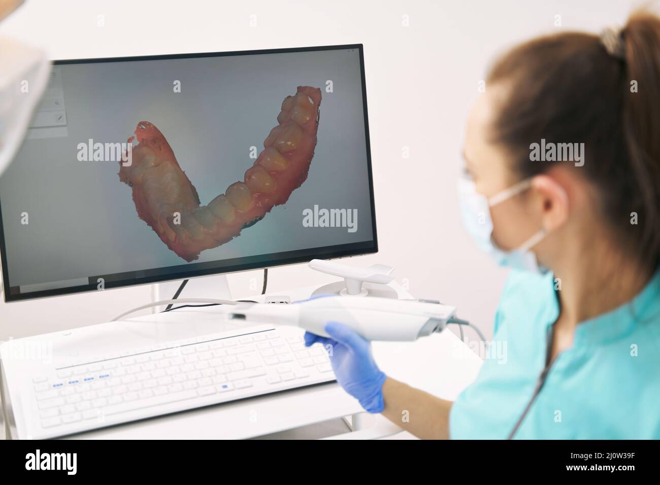 Dentist analyzing 3D scan of patient teeth in clinic Stock Photo - Alamy