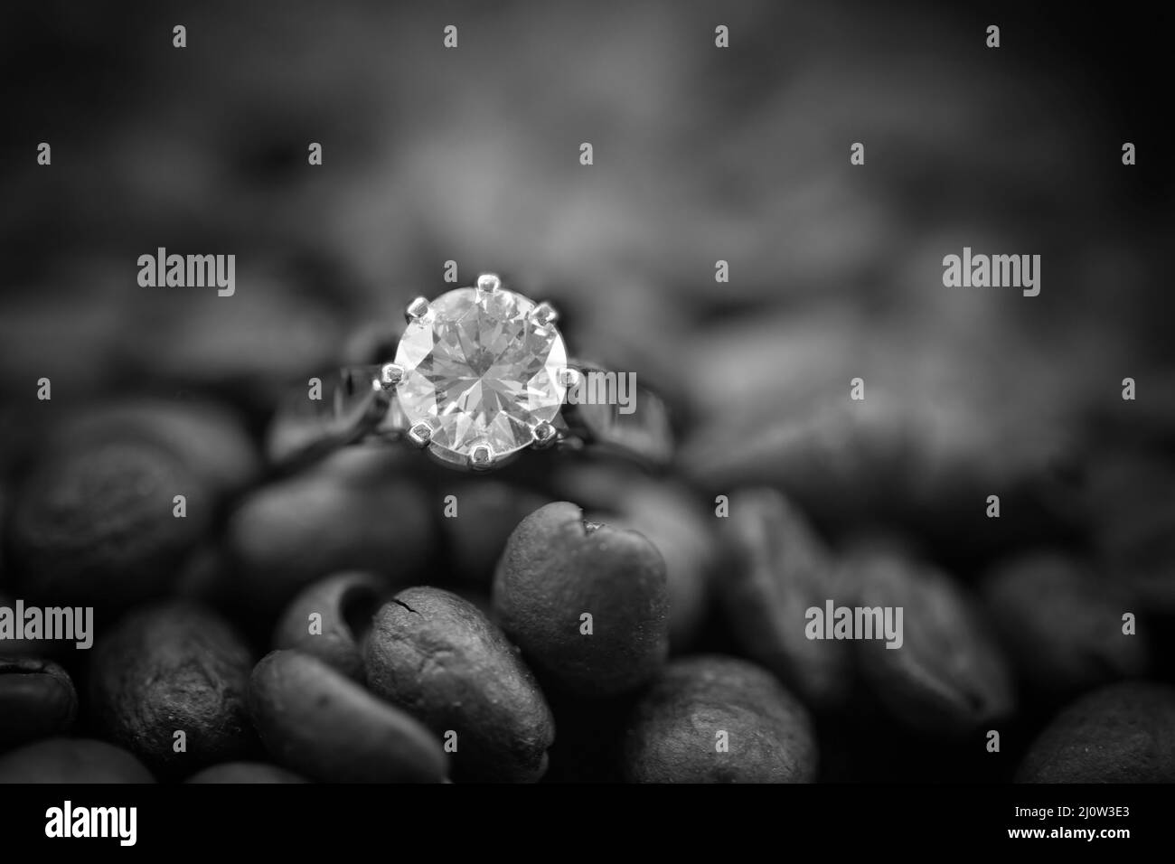 A claw set two carat diamond ring nestled amongst coffee beans Stock ...
