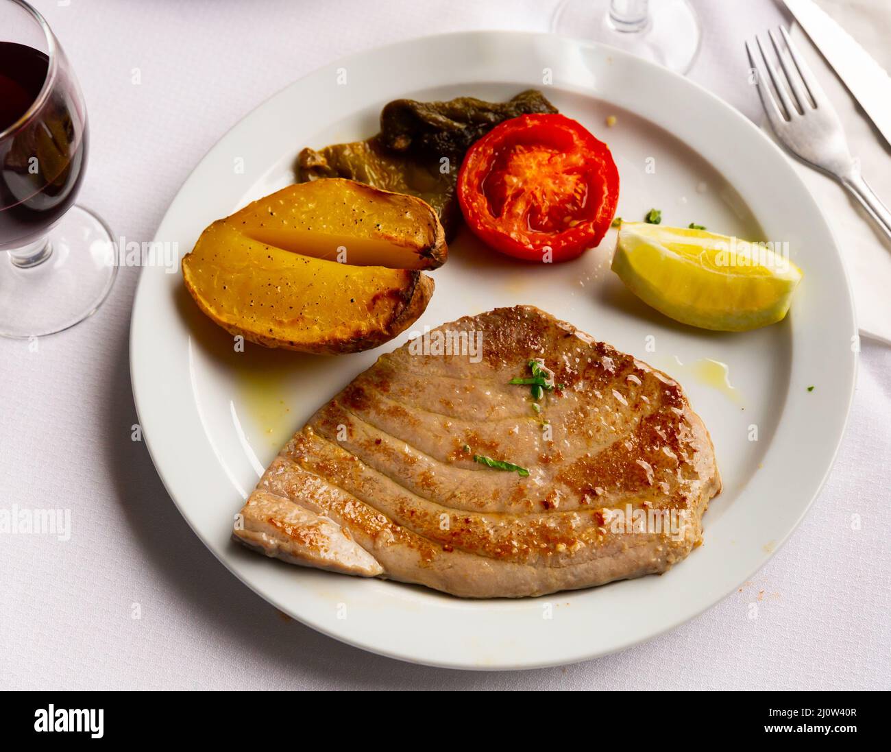 Fried tuna steaks with tomatoes and lemon Stock Photo - Alamy