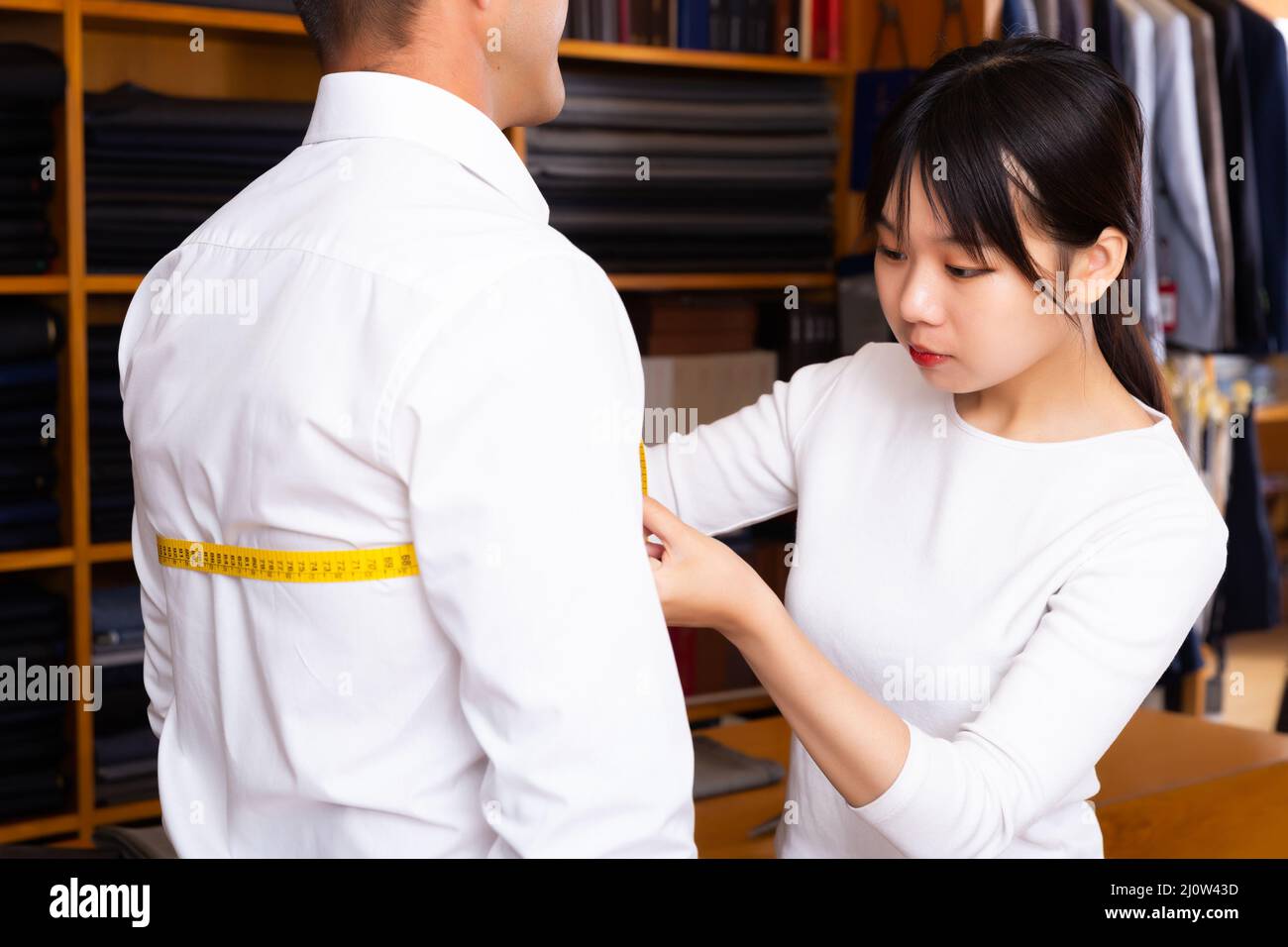 Woman tailor taking measurements man Stock Photo - Alamy