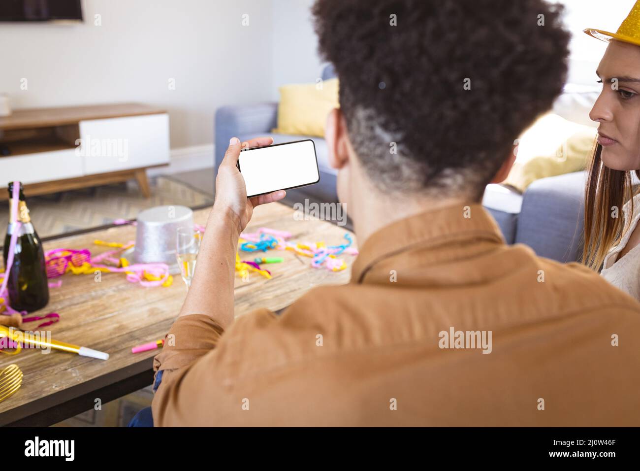 Young man sharing blank smart phone screen with girlfriend at home ...