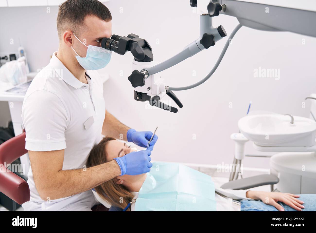 Dentist examining woman teeth with microscope in dental clinic Stock ...