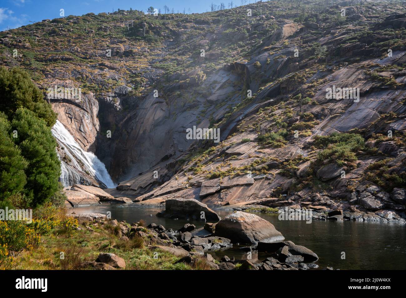 Ezaro waterfall water crashing on lake between rocks in Spain Stock ...