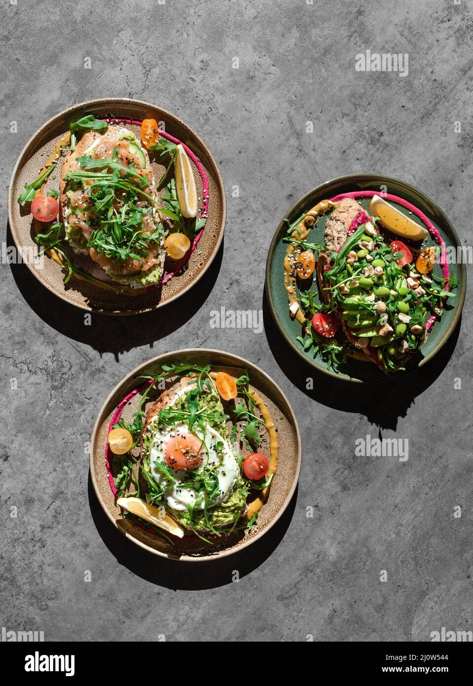 Top view of three plates with different types and portions of breakfast ...