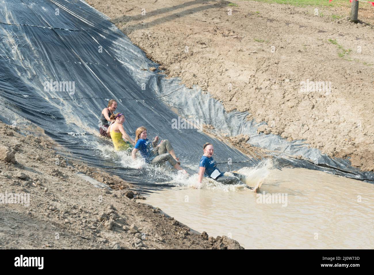 Four female competitors slide down the hill and into the Swampfoot Run ...