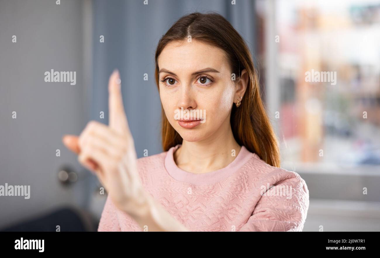 Girl checks her eyesight - carefully looks at her finger. Gymnastics ...
