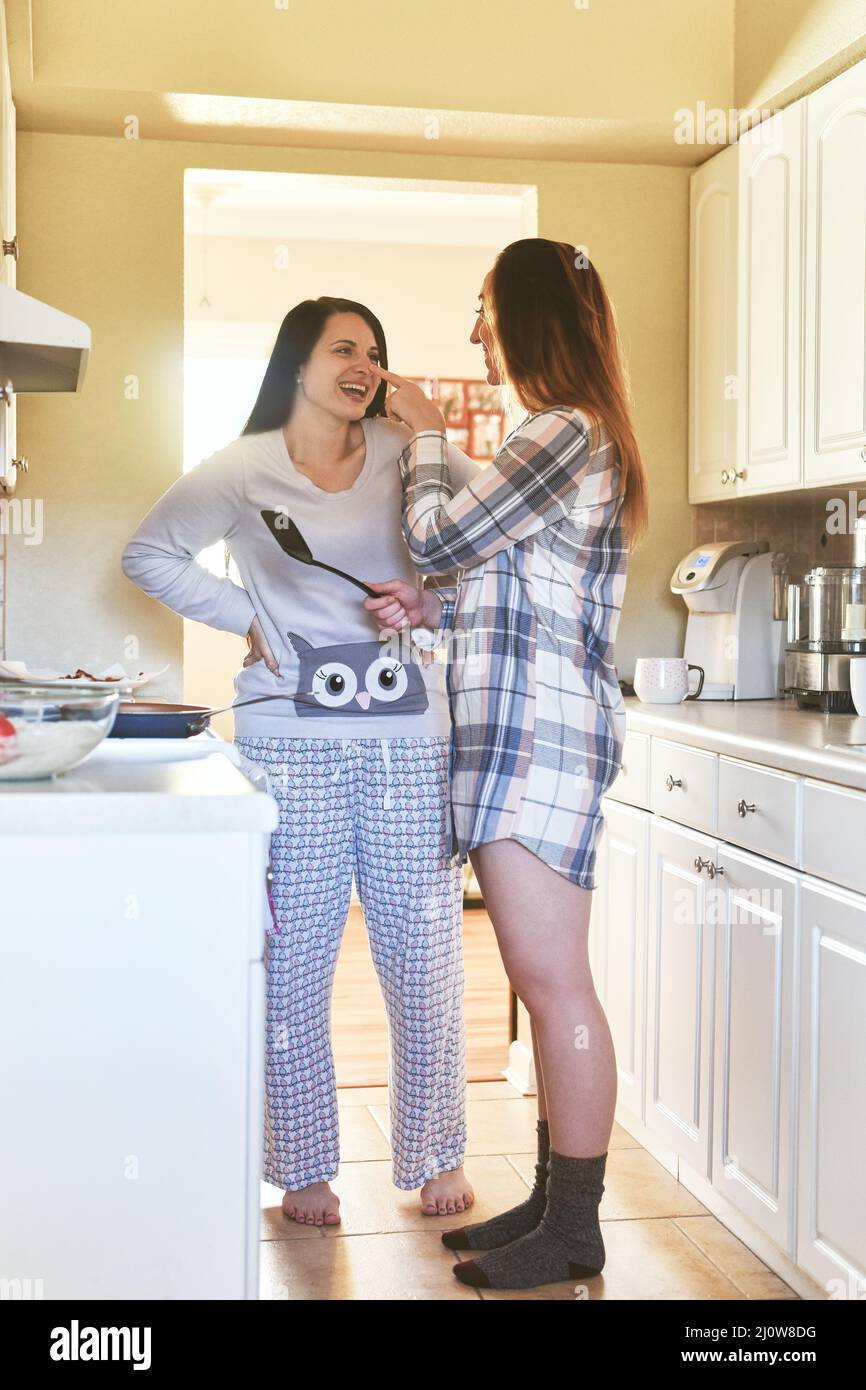 First things first we make breakfast. Shot of two young women making ...