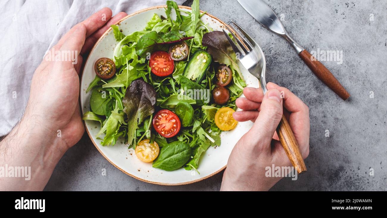 Man eating vegetarian vegetables healthy salad with red and yellow ...