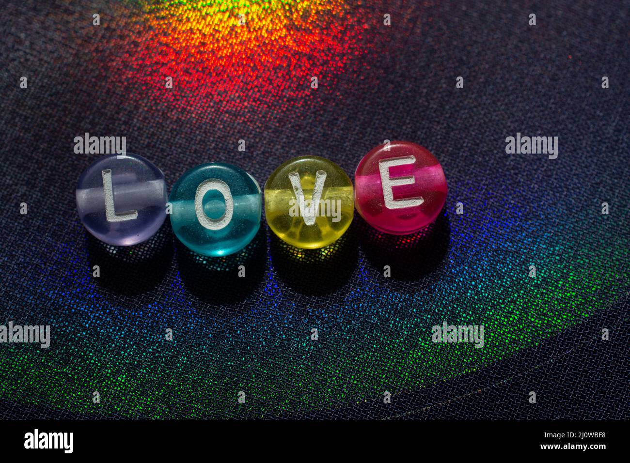 The word love with beads letters as love concept on colorful background ...